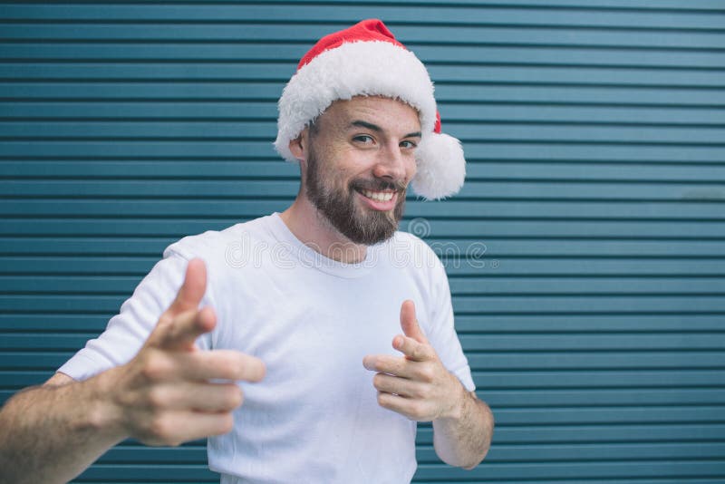 Positive Guy with Santa Hat is Looking on Camera and Smiling. he is ...