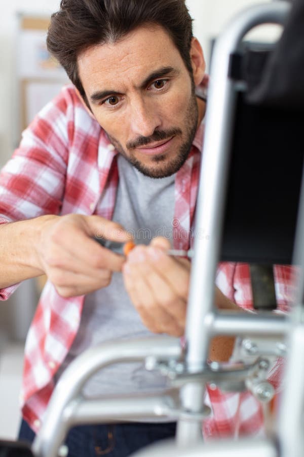 Positive Handsome Young Man Using Screwdriver for Fixing Something ...