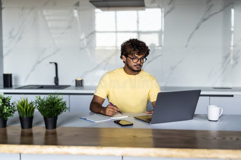 Positive Indian Man Looking for Job Online, Sitting at Table, Using ...
