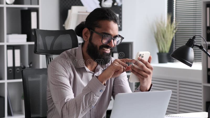 Positive Indian Office Worker Browsing Phone Content at Office Stock ...