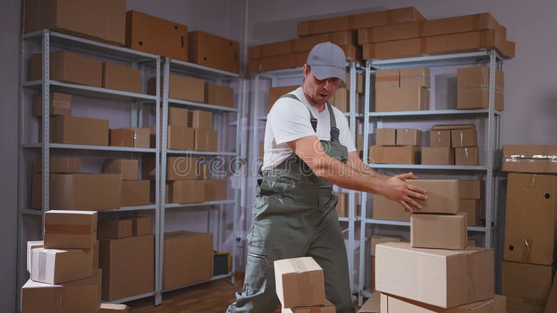 A Positive Male Movers in Uniform Dancing in a Warehouse,folding Boxes ...