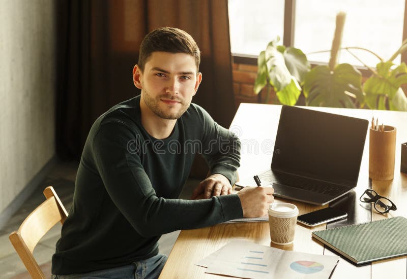 Positive Man at Laptop Computer Working Taking Notes Sitting Indoor ...