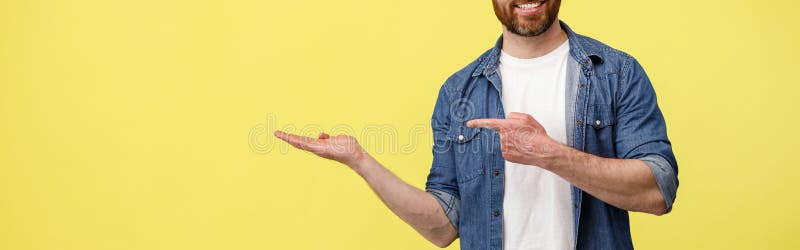 Positive Man Stands on Yellow Background Points His Finger To Side in ...