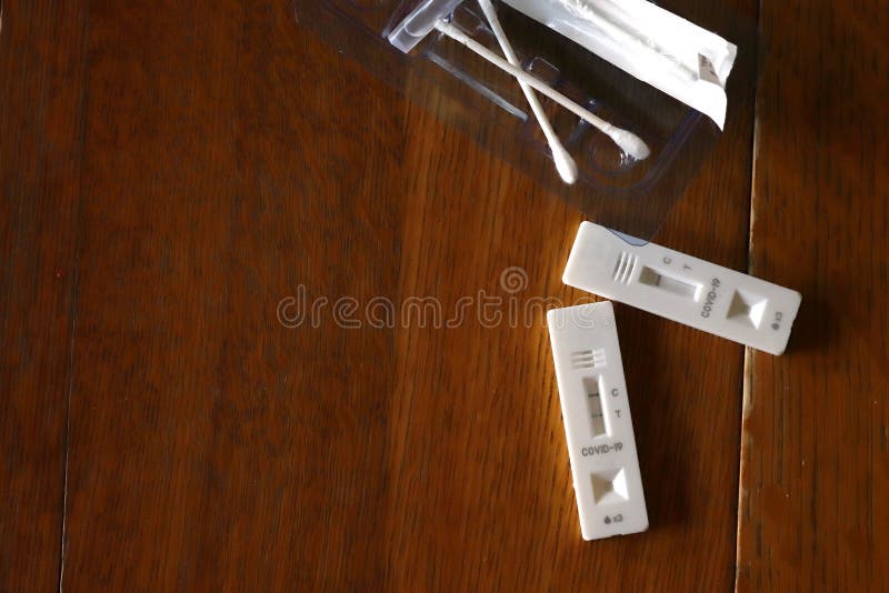 A Positive and Negative Home Test Kit for Coronavirus on a Wooden ...