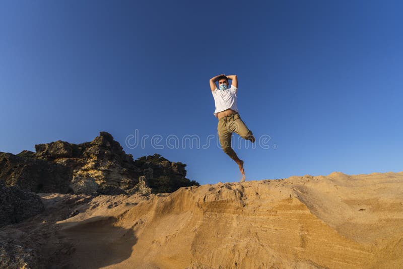 Positive Picture of a Jumping Man in a Steppe with Mask Stock Photo ...