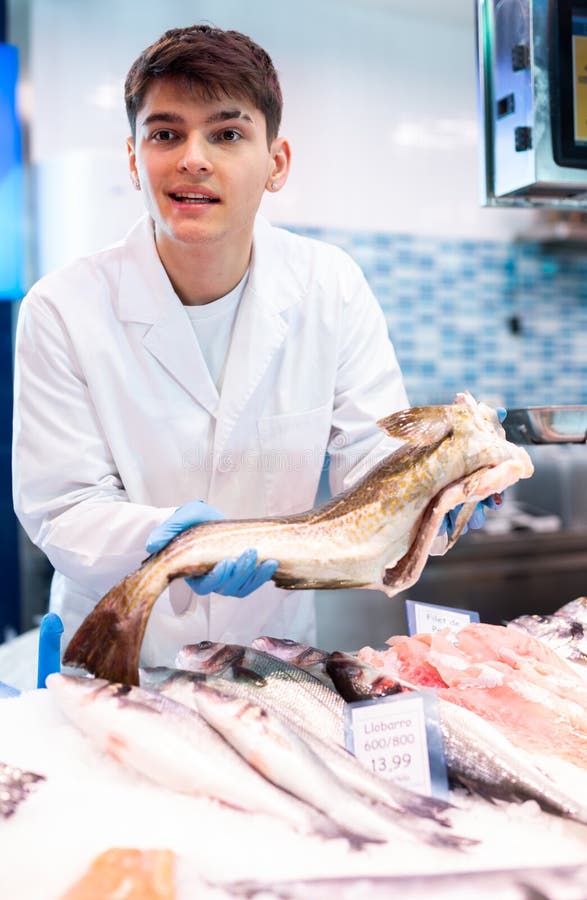 Positive Salesman Demonstrating Cod in Fish Store Stock Photo - Image ...