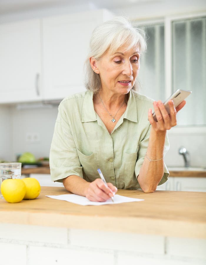 Positive Senior Woman Talking on Phone and Making Notes Stock Image ...
