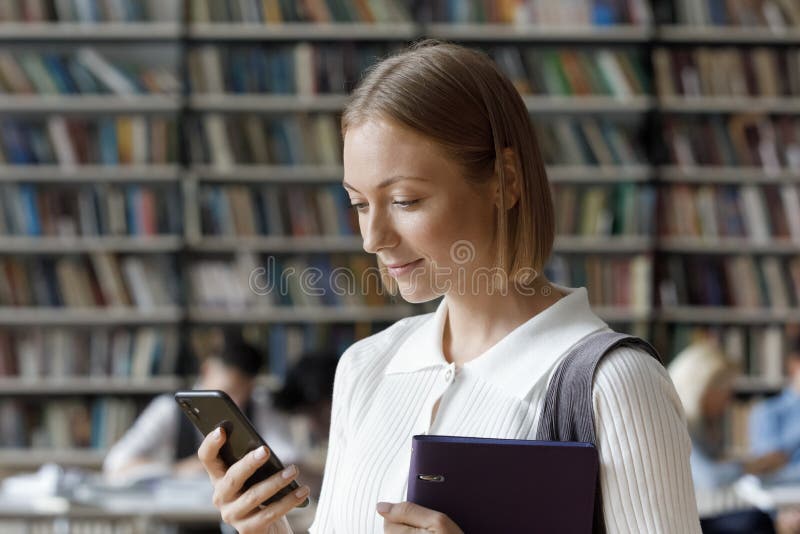 Positive Student Girl Using App on Smartphone in College Library Stock ...