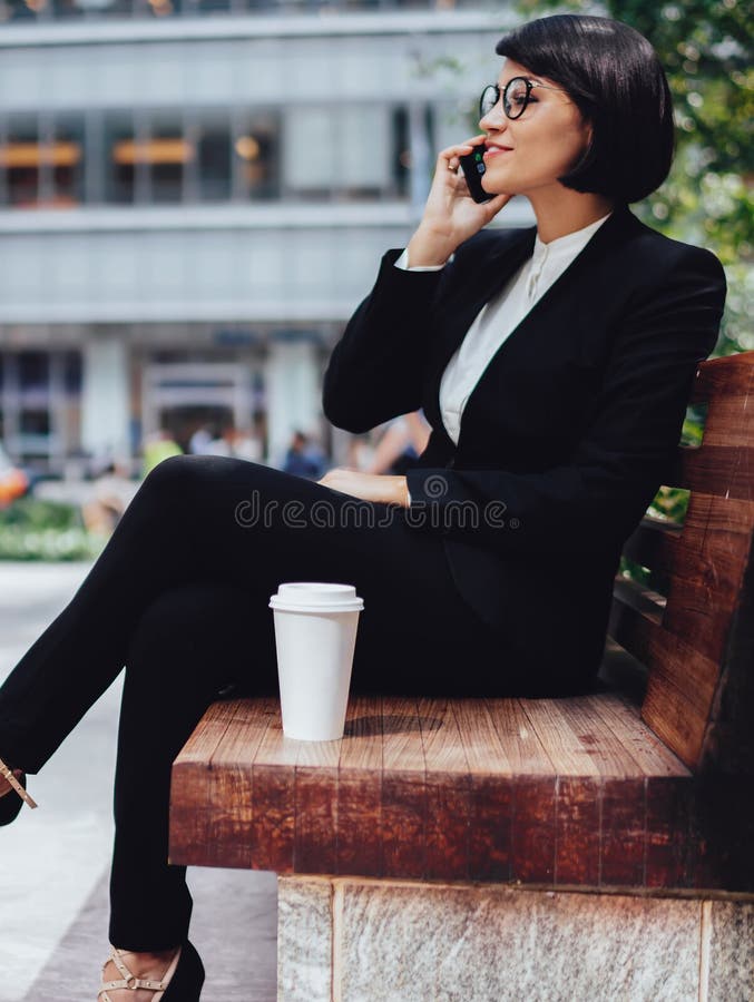 Positive Woman Dressed in Elegant Wear Resting on Bench Using ...