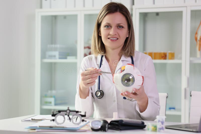 Positive Woman Points Pen To Realistic Model of Eyeball Stock Photo ... Positive Woman Points Pen To Realistic Model of Eyeball Stock Photo ...