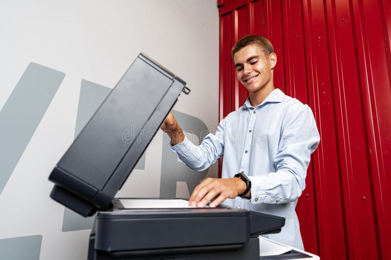 Positive Young Man Using Printer in the Modern Office Stock Image ...