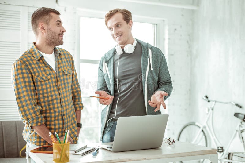 Positive Young Men Having a Conversation at Work Stock Image - Image of ...