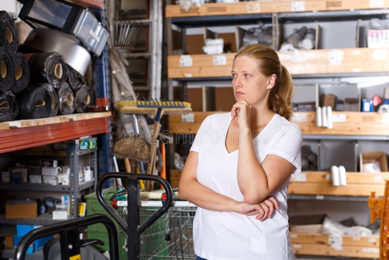 Positive Young Woman Looking Tools with Note List in Build Store Stock ...