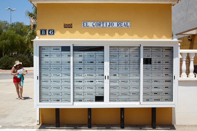 Post Office Mail Boxes Lining a Wall Outside and Woman. El Coptijo Real ...