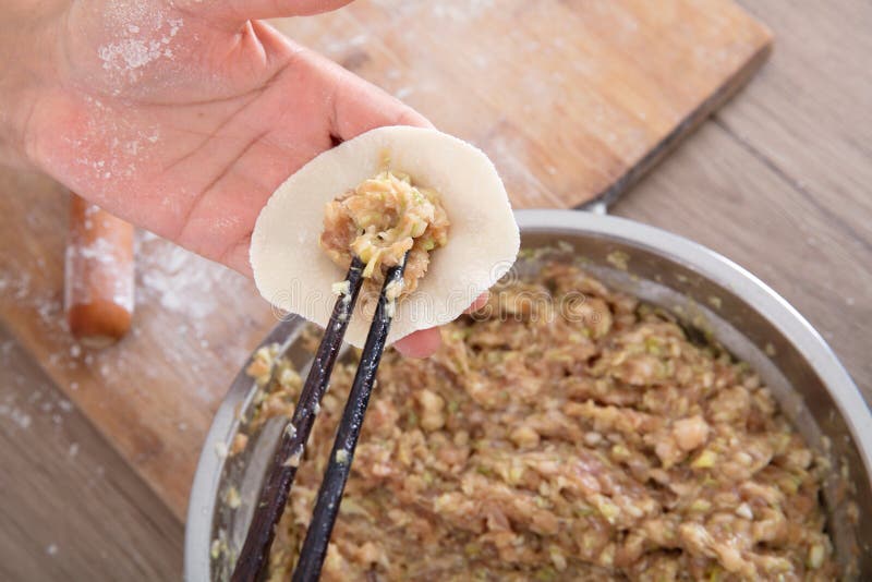 A Pot of Dumpling Stuffing and Two Hands are Making Dumplings Stock ...