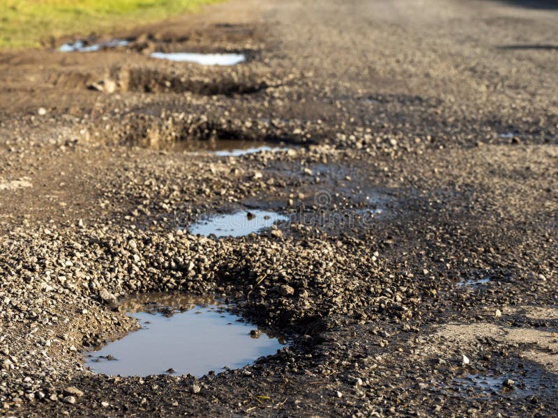 Pot Holes Filled With Water On A Small Rural Road Dangerous Road