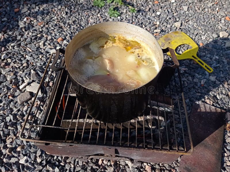 A Pot of Soup Sitting on Top of a Grill on the Ground Stock Image ...