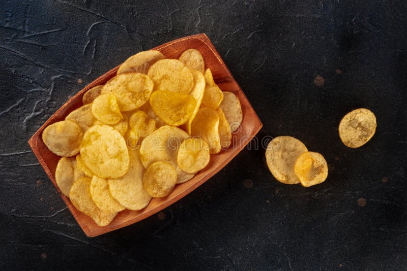 Potato Chips or Crisps, a Salty Snack, Shot from the Top on Black Stock ...