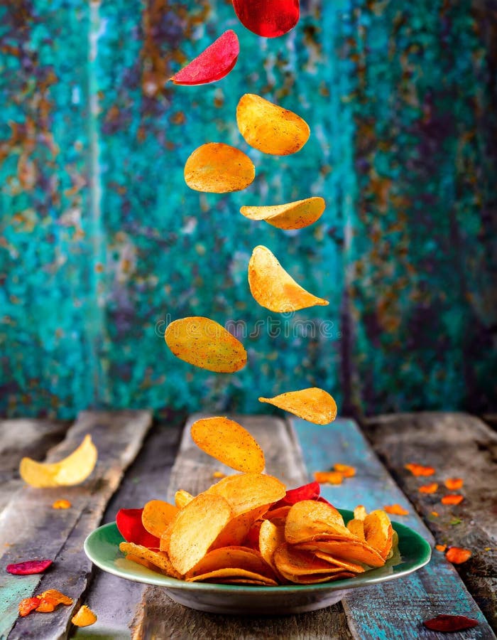 Potato Chips Falling Down on an Old Rustic Wooden Table Stock ...