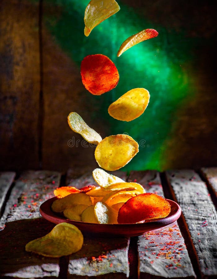 Potato Chips Falling Down on an Old Rustic Wooden Table Stock ...