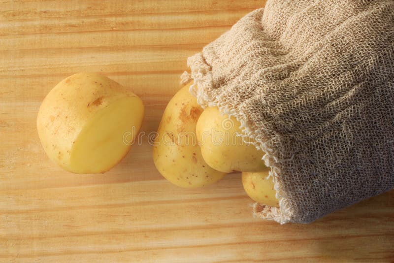 Potato Sticking Out of Sack on Wooden Table, Cut Potato Stock Photo ...