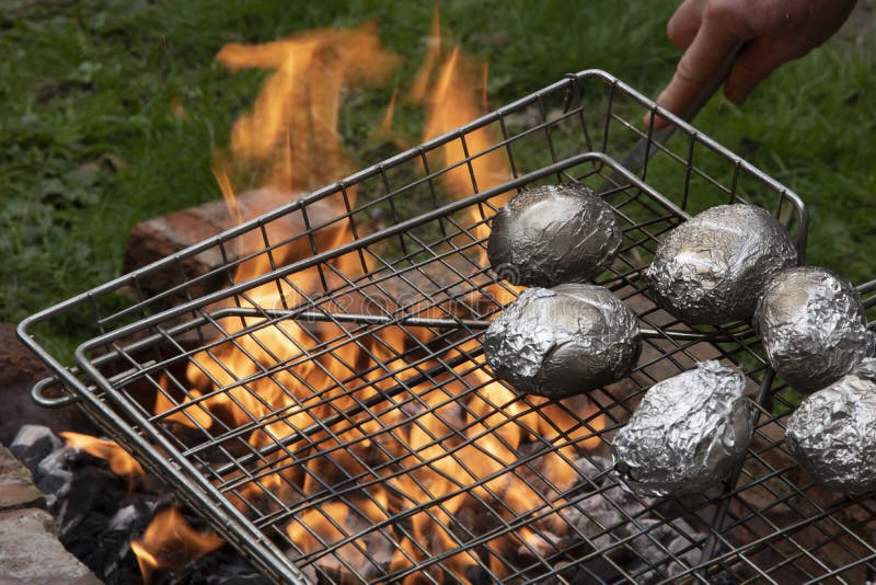 Potatoes in Foil Being Cooked on Fire, Barbecue Stock Image - Image of ...