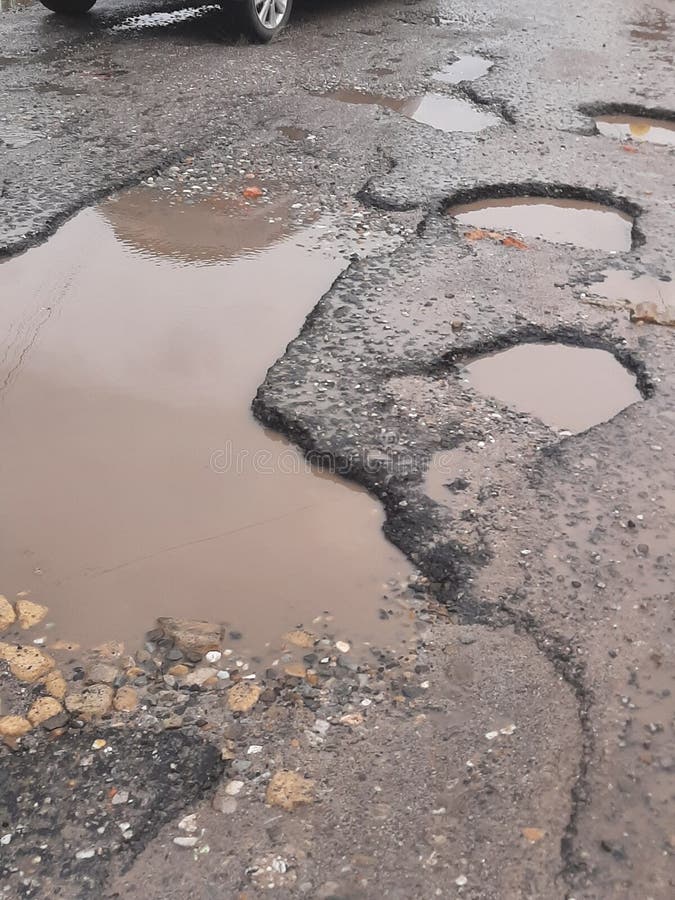 Potholes in the road stock image. Image of road, sludge - 355298701