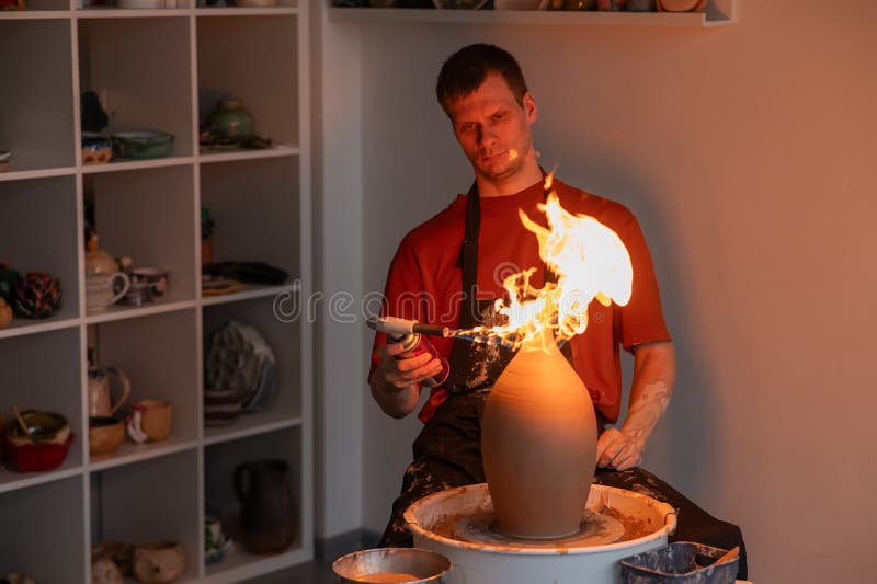 A Potter Burns a Jug with a Gas Burner on a Potter& X27;s Wheel. Stock ... A Potter Burns a Jug with a Gas Burner on a Potter& X27;s Wheel. Stock ...
