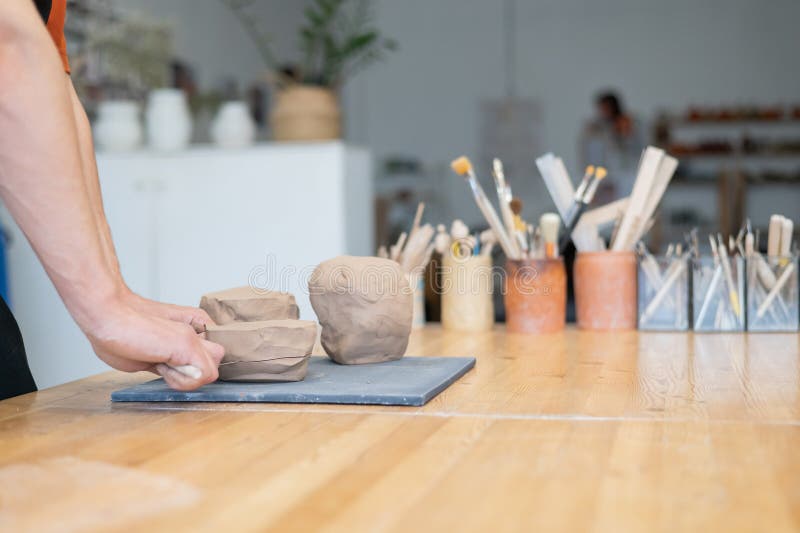 A Potter Cuts a Piece of Clay into Pieces before Using it in the ...