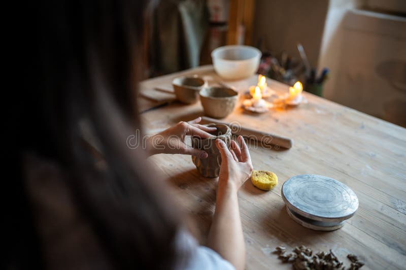 Female Ceramist Molds Clay Cup with Decorative Pattern on Wood Table in ...