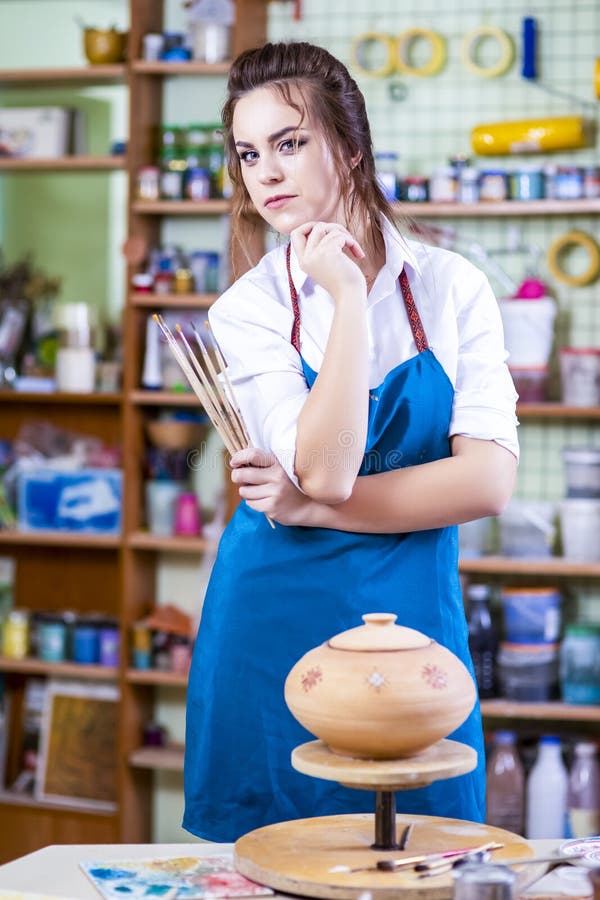 Pottering Ideas. Female Worker in Blue Apron Posing with Paint Brushes ...