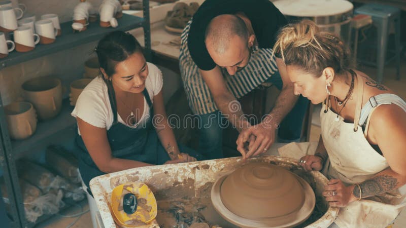 Pottery Wheel, Teacher and Class of People Learning Workshop Skill, Sculpture Design or ...