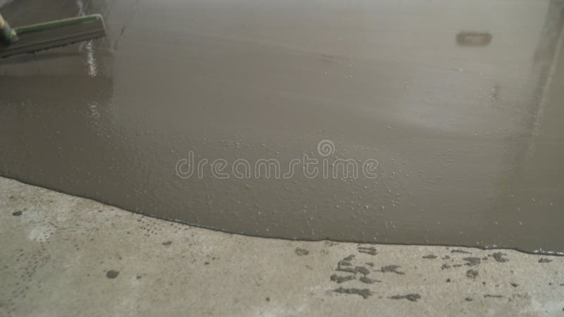 Pour the Liquid Floor Onto the Concrete Surface. Leveling the Floor ...