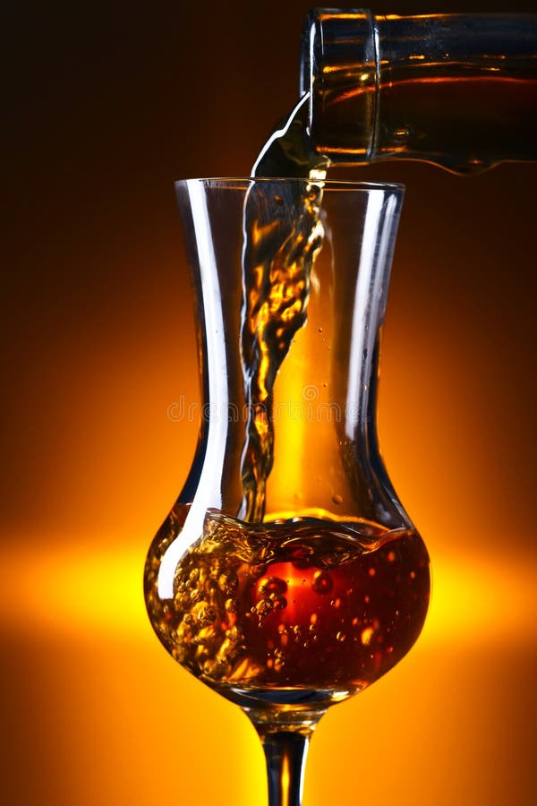 Pouring Alcohol into a Glass on Dark Background Stock Image - Image of ...