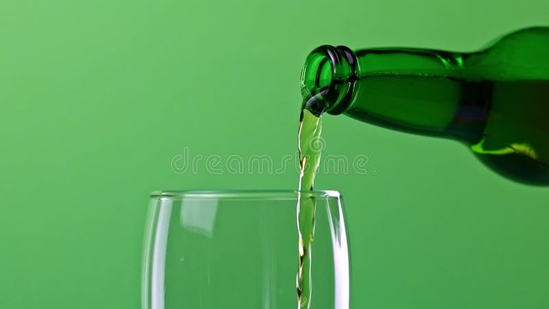 Pouring Beer Into A Glass From A Glass Bottle Fresh Beer In A Glass On A Green Stock Video