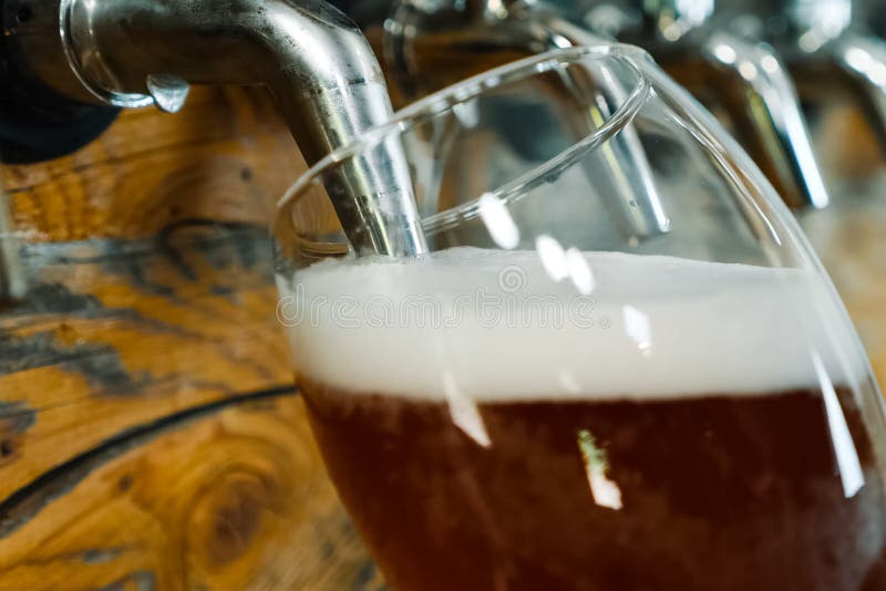 Pouring Beer Into A Glass From The Tap At Bar Beer Bottling Stock