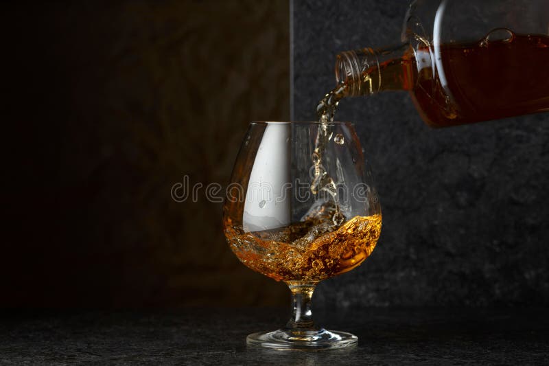 Pouring Brandy from a Bottle into a Glass Stock Photo - Image of ...