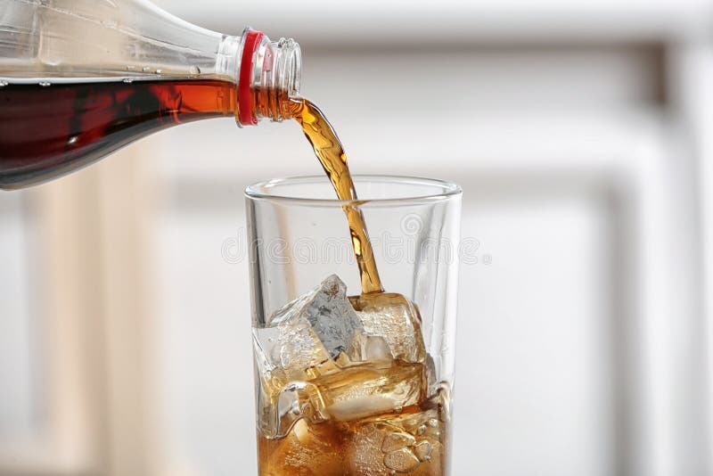 Pouring Cola from Bottle into Glass on Blurred Background Stock Image ...