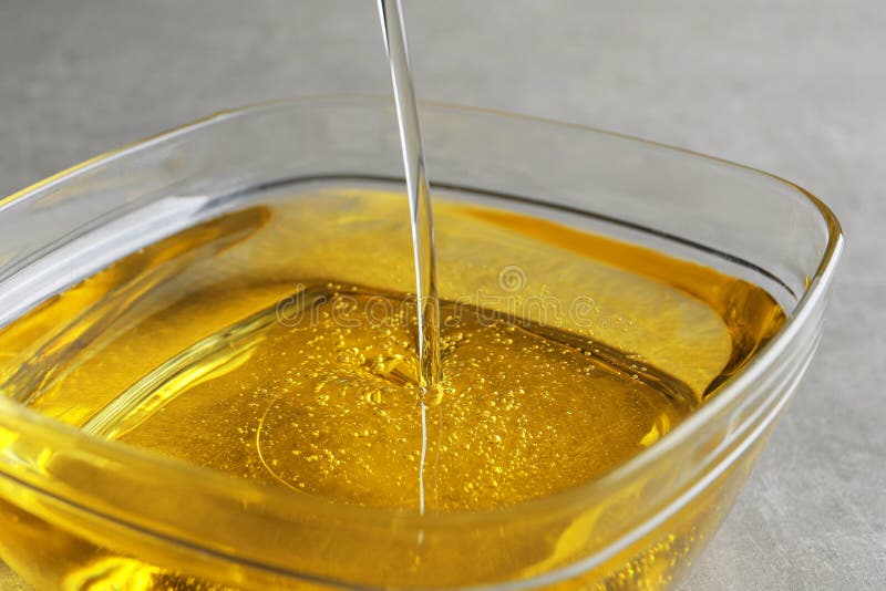 Pouring Cooking Oil into Bowl on Light Background, Closeup Stock Image ...