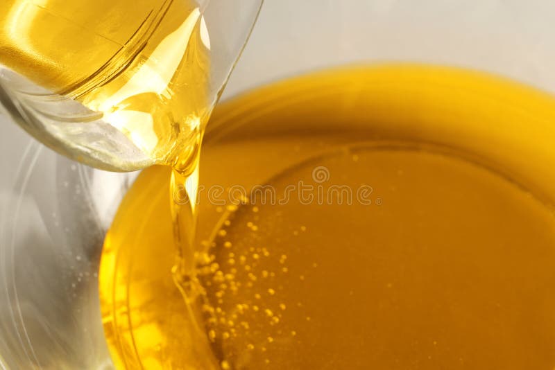 Pouring Cooking Oil from Jug into Bowl, Closeup Stock Image - Image of ...