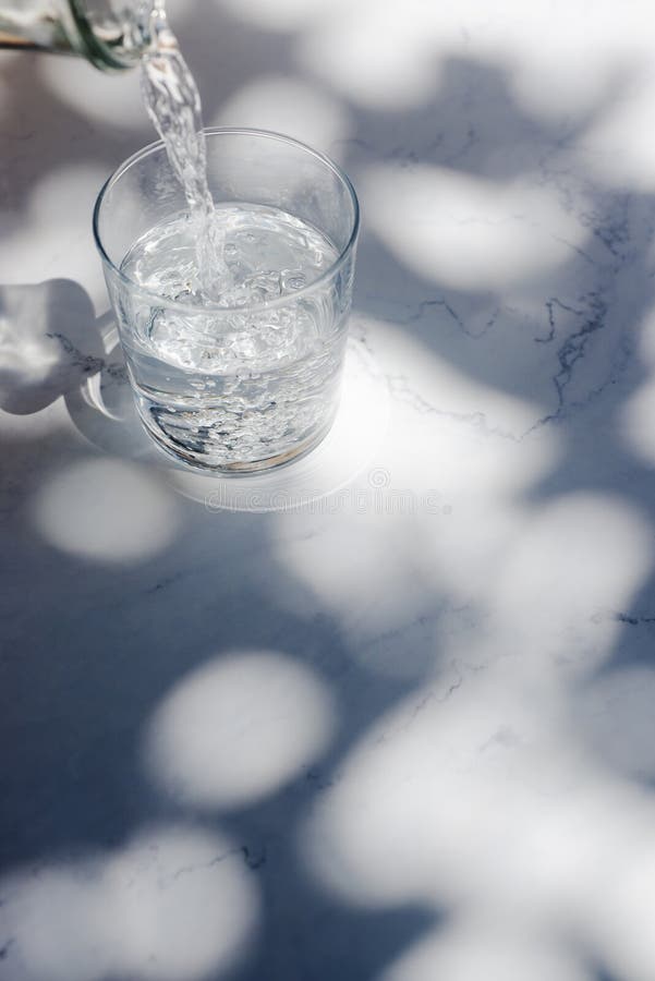 Pouring Drinking Water into Glass on White Marble Table Stock Image ...