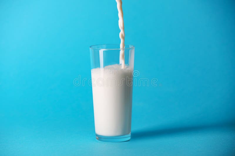 Pouring Fresh Milk into Glass on Light Blue Background Stock Image ...