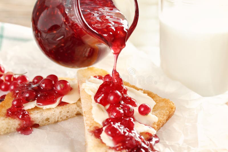 Pouring Jam from Jug Onto Toast with Red Currant on Table Stock Photo ...