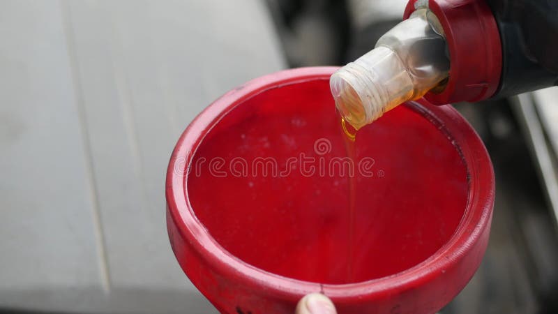Pouring Liquid into Red Funnel for Engine Maintenance Stock Footage ...