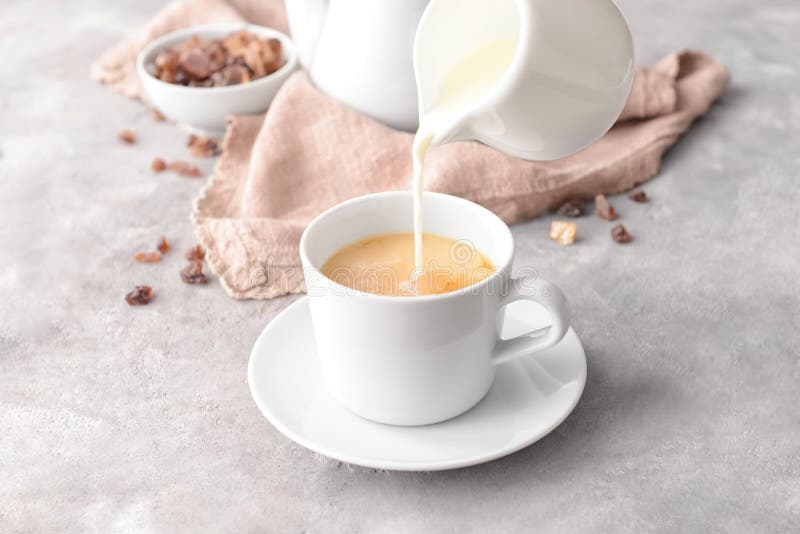 Pouring of Milk into Cup of Tea on Table Stock Photo - Image of pouring ...
