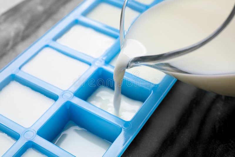 Pouring Milk into Ice Cube Tray at Table Stock Photo - Image of natural ...