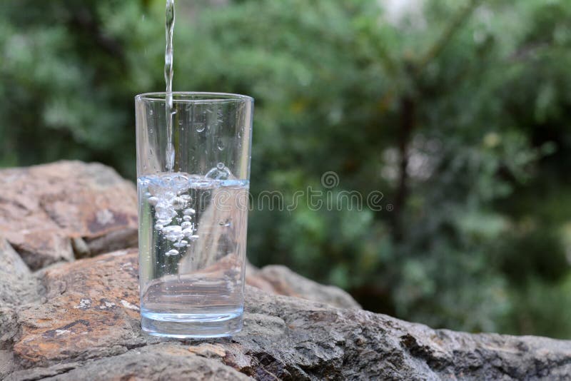 Pouring Pure Water into Glass on Stone Outdoors, Space for Text Stock ...