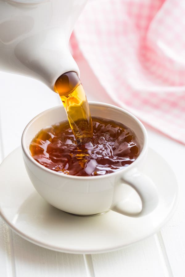 Pouring tea into a cup. stock image. Image of pouring - 80164809
