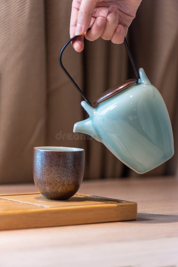Pouring Tea from a Teapot into a Cup on the Table Stock Photo - Image ...