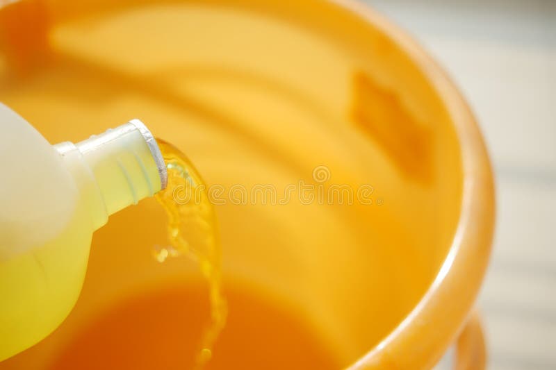 Pouring Washing Liquid into an Orange Bucket during Cleaning Task Stock ...